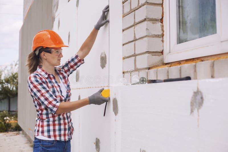 Insulation of the House with Polyfoam. the Worker is Checking with the ...