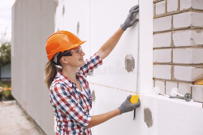 Insulation of the House with Polyfoam. the Worker is Checking with the ...