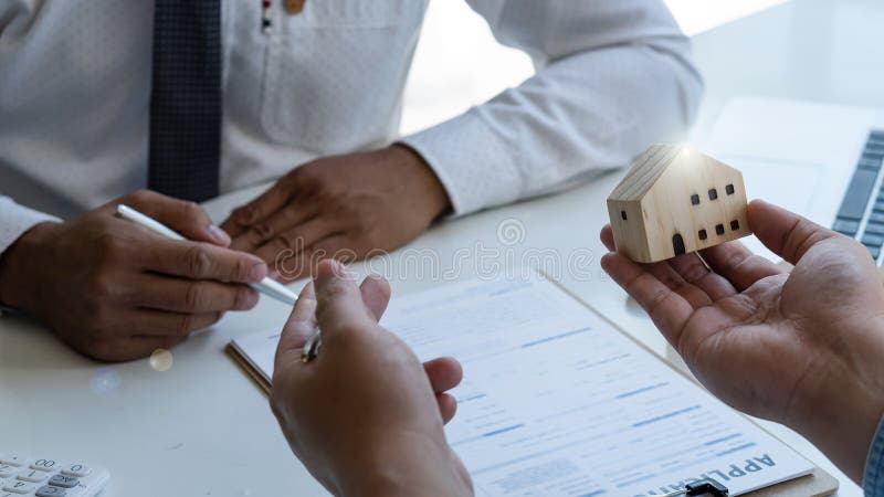 The Insurance Agent Holds a Small Sample Home Design in Hand, Showing ...