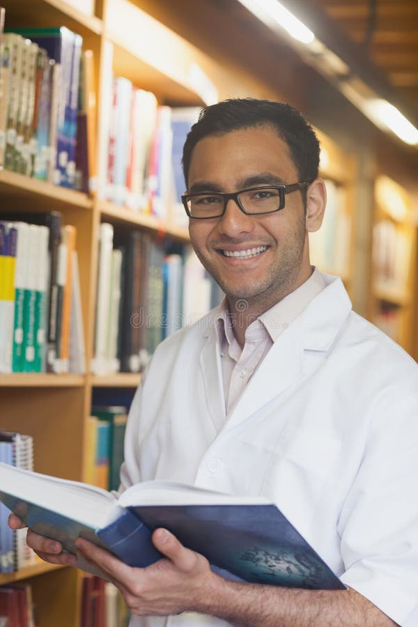 Intellectual Handsome Man Posing Holding an Opened Book in Library ...