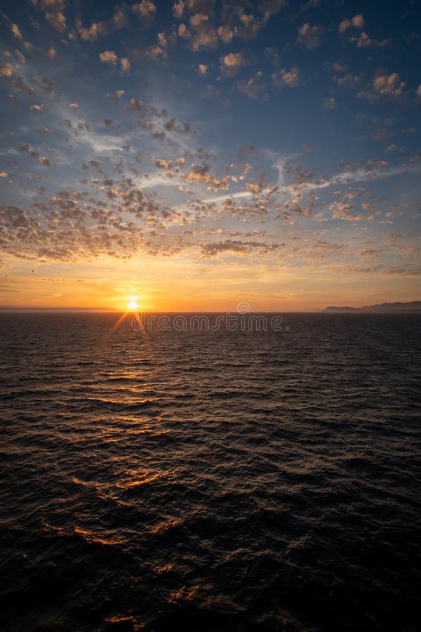 Intense Evening Sky with Whispy Clouds and Ripples on Ocean Stock Photo ...