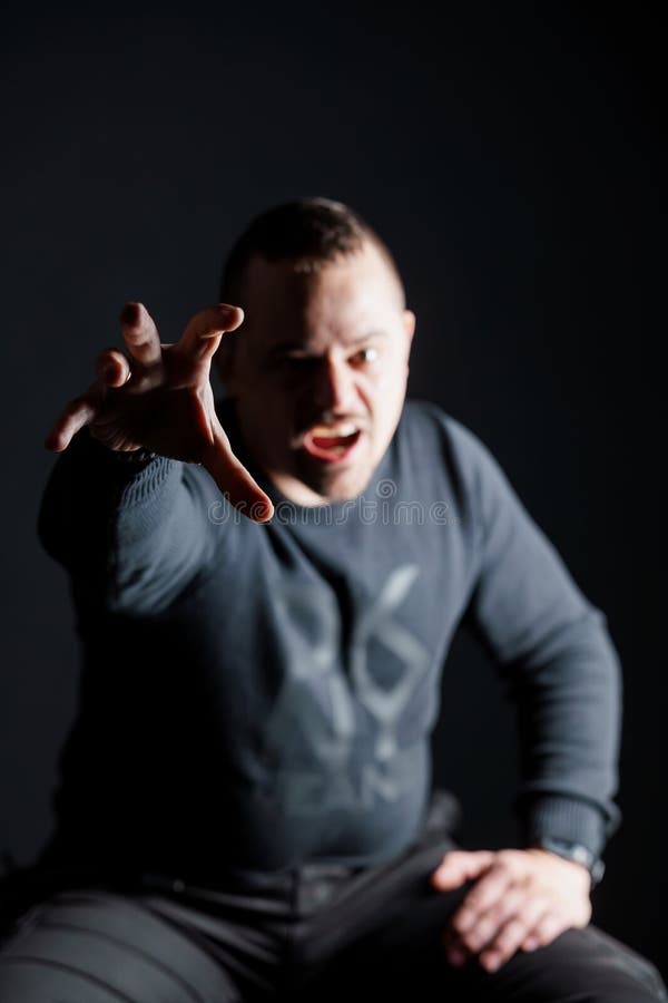 Intense Expression of Anger and Determination in Dark Setting Stock ...