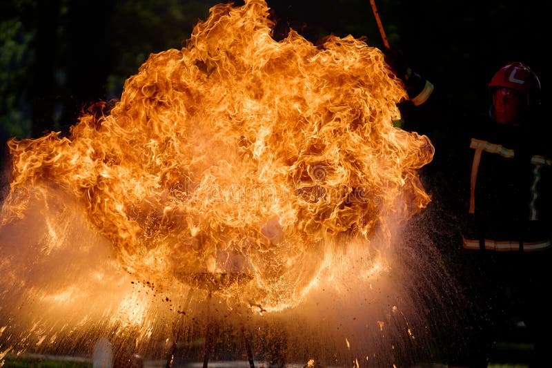 Intense Fire Burst. Dramatic Close-up of a Firefighter Managing a Large ...