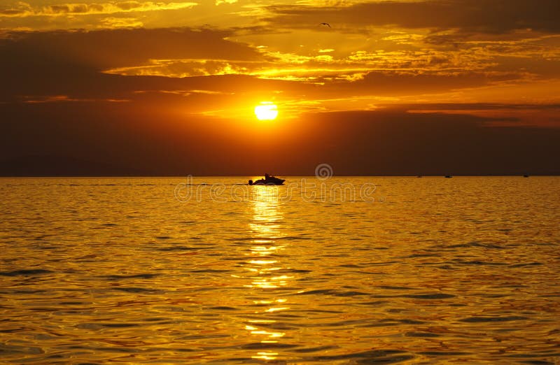 An Intense Orange Sky Above the Shiny Undulating Surface of the Sea at ...