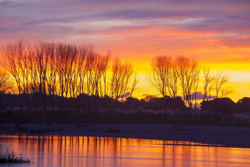 Intense Sunset Colours Beyond Bay Water and Silhouette Landscape Stock ...