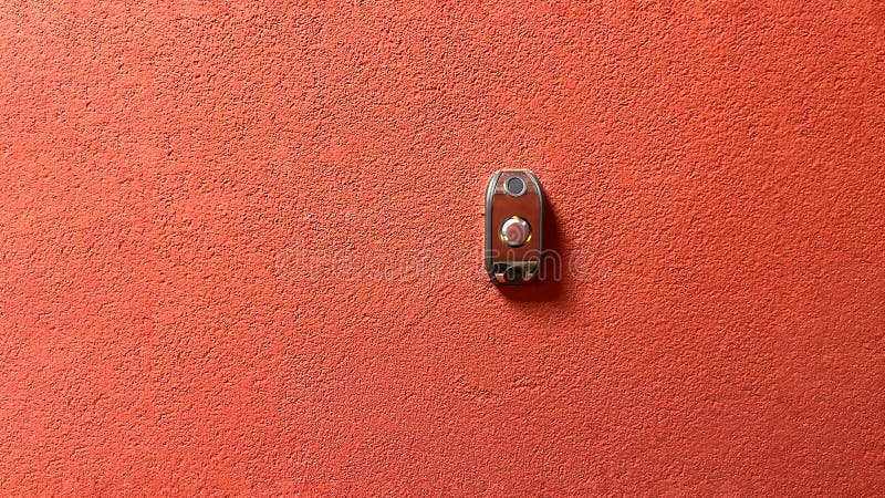 An Intercom with a Metal Call Button Mounted on a Red Wall, a Help or ...