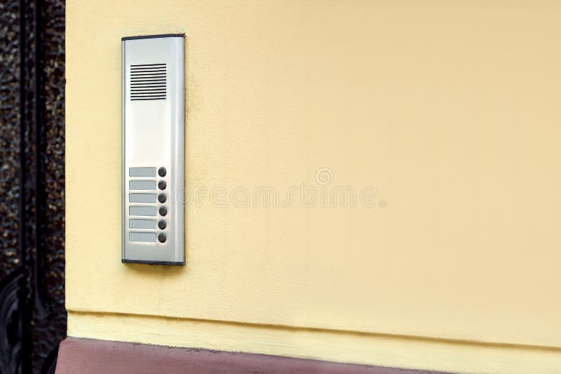 Intercom with a Microphone and Call Buttons Mounted on a Yellow Wall ...