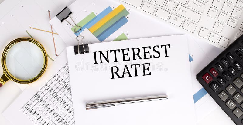 INTEREST RATE Text on White Paper on the Light Background with Charts ...