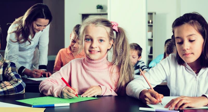 Interested Little Children with Teacher Drawing in Classroom Stock ...