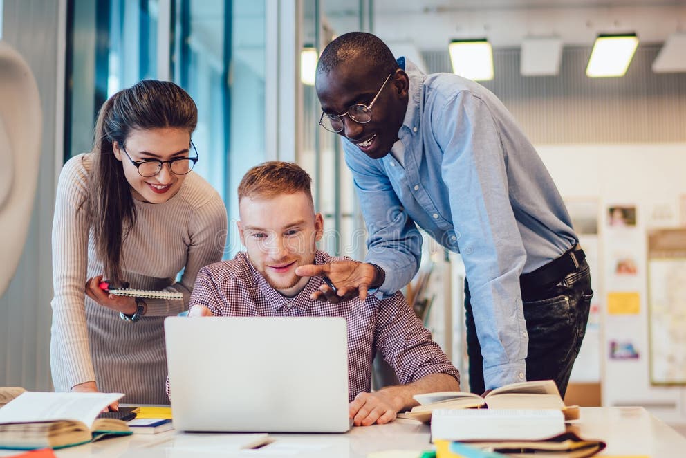 Interested Multiracial Students Doing Research and Browsing Laptop in ...