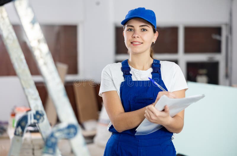 Positive Young Female Builder Contractor Inspecting Room and Taking ...