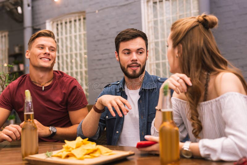Three Young People Talking and Eating in the Bar Stock Image - Image of ...