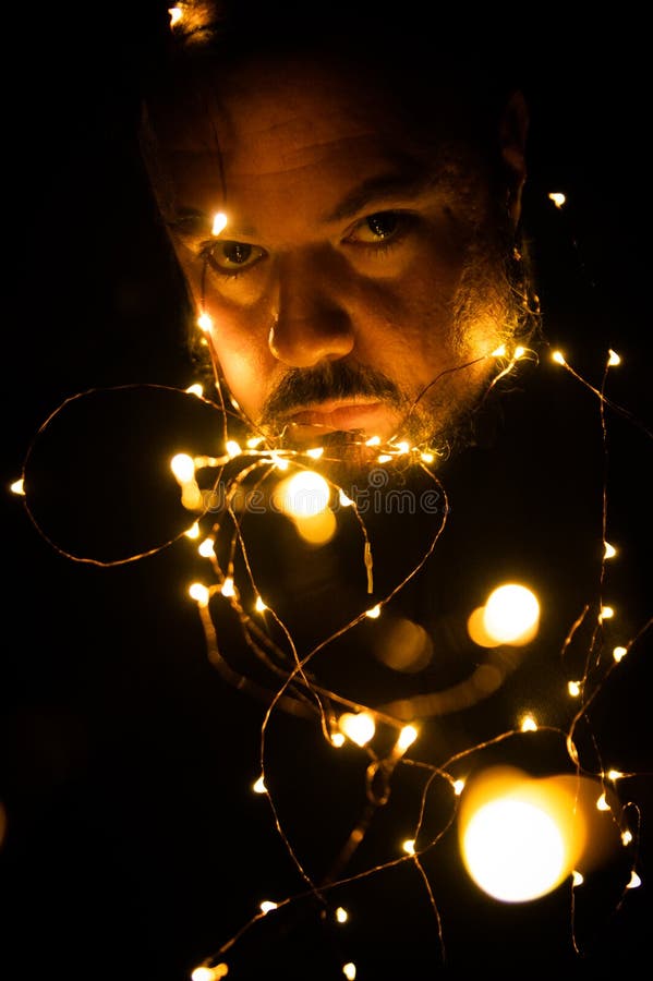 Interesting Man Surrounded by Christmas Lights.Isolated on Black ...