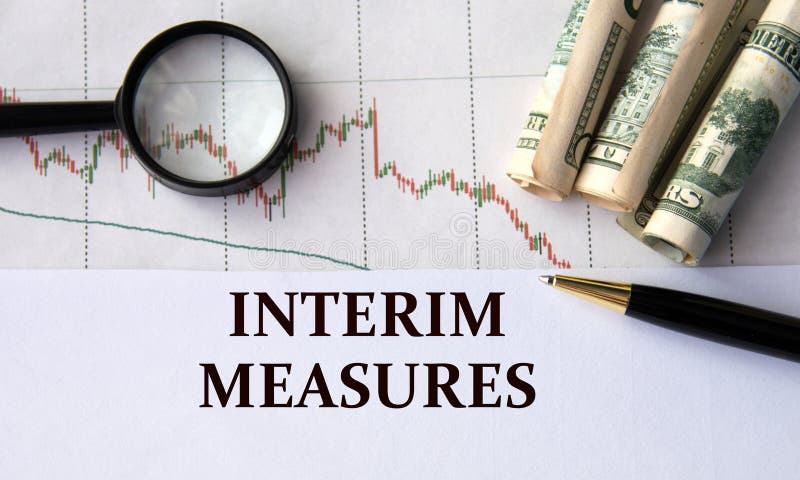 INTERIM MEASURES - Words on a White Sheet Against the Background of a ...