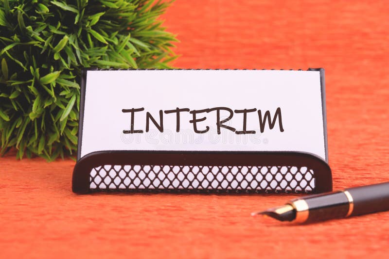 Interim Writing on a White Business Card in a Business Stand in Front ...