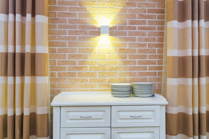 Interior with Brick Wall Chest of Drawers and a Stack of Plates Stock ...