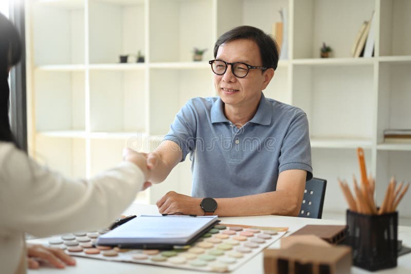 Interior Designer and Client Shaking Hands after Signing Agreement at ...