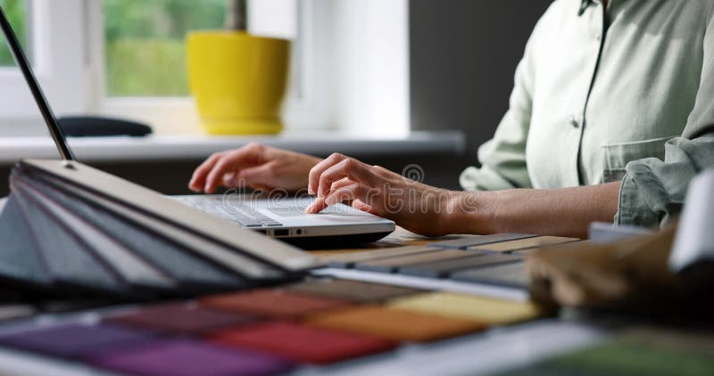 Interior Designer Working on Laptop in Office. Design Material Samples ...