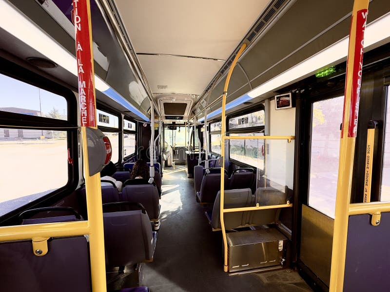 Interior of an Empty City Bus with a Few Passengers Seated at the Back ...