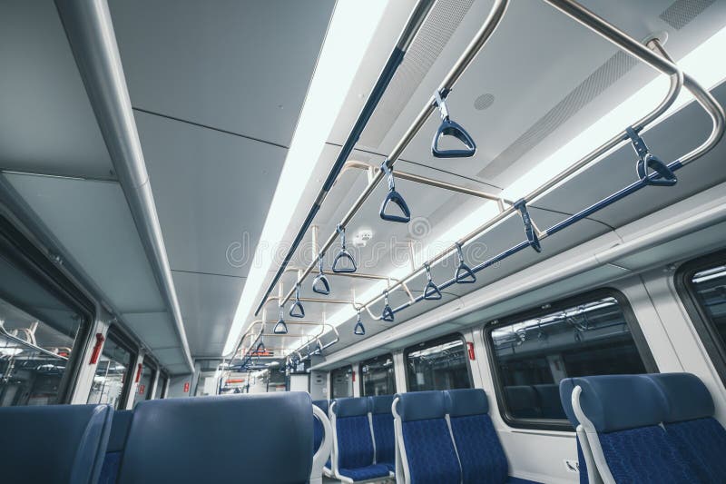 Interior of an Empty Train with Blue Seats and Overhead Handrails Stock ...