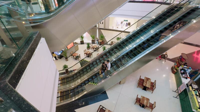 Interior of a Modern Shopping Mall with Escalators Shoppers and Seating ...