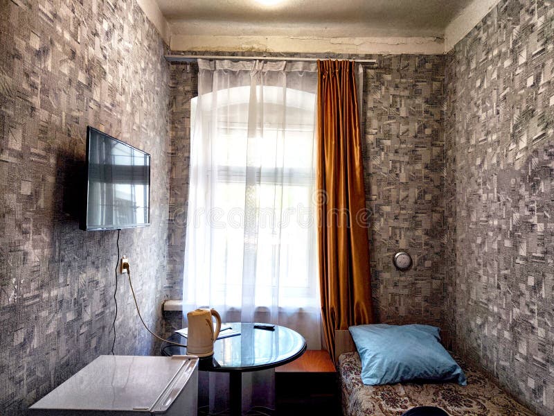 The Interior of a Poor Room. the Room Features a Small Table, a Window ...