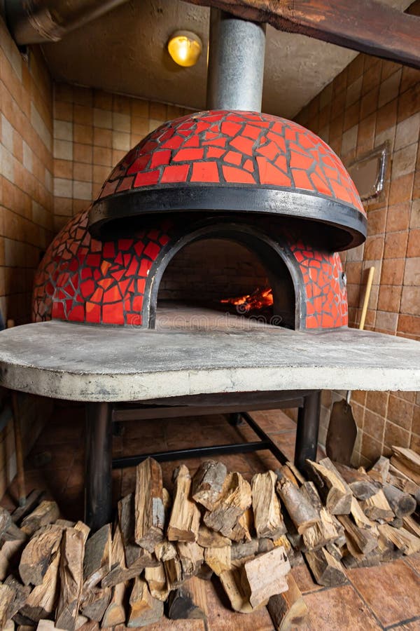 Interior Shot of a Rustic Wood Fired Oven with a Pile of Logs beside it ...