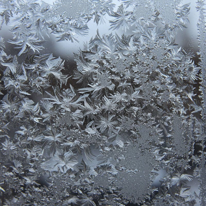 Interlocking Patterns of Frost Crystals Cover a Glass Surface, Creating ...