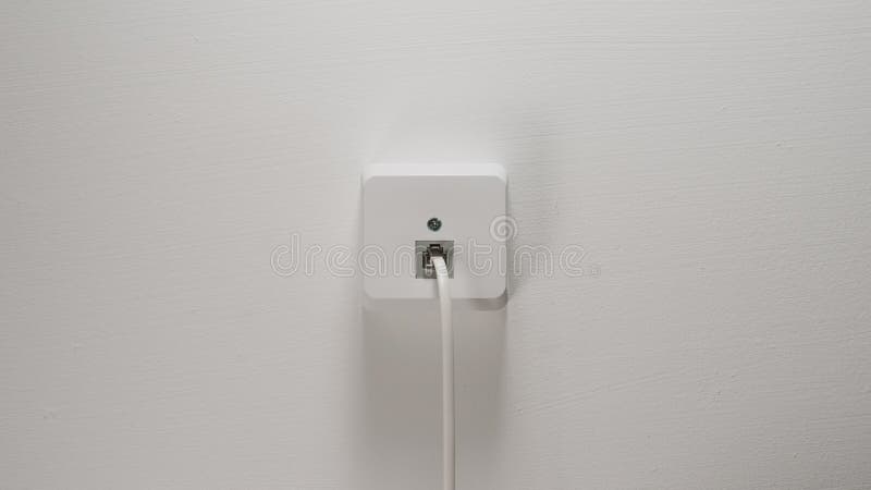 Internet Cord into Wall Socket on a White Wall Stock Image - Image of ...