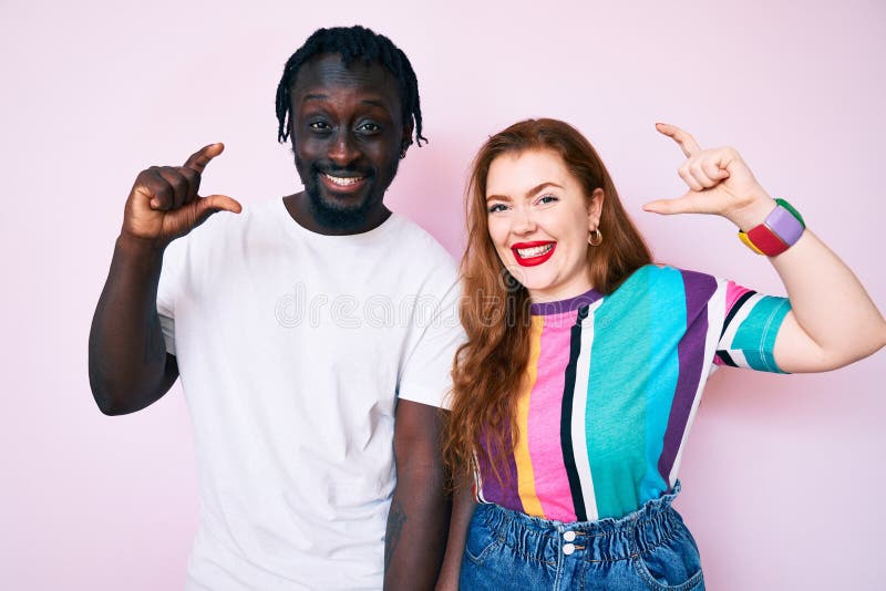 Interracial Couple Wearing Casual Clothes Smiling And Confident
