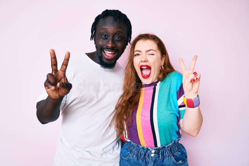 Interracial Couple Wearing Casual Clothes Smiling With Happy Face