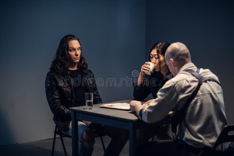 In the Interrogation Room, the Investigator Shows the Suspect Evidence ...