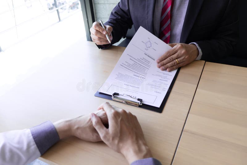Interview Employee Reading a Resume with the Job Seeker Sitting in ...