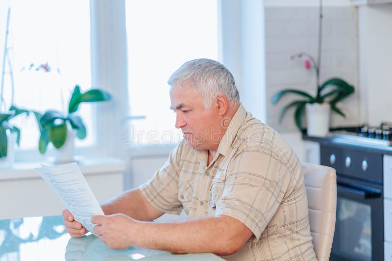 Document Inspection Elderly Man Concentrating on Reading at Home ...