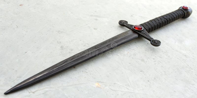Intricately Designed Dagger with a Decorative Handle Rests on a Flat ...