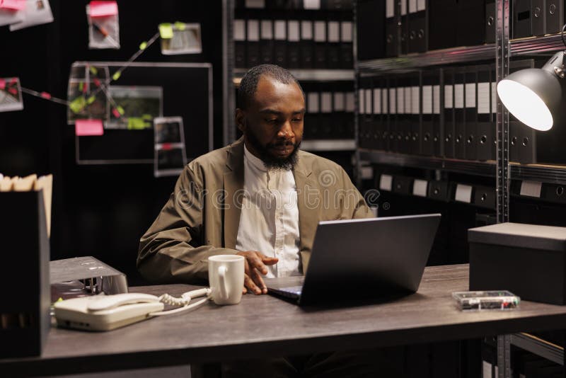 Investigator Sitting at Desk, Working on Laptop at Night Stock Photo ...