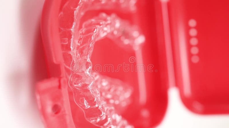 Invisalign Clear Aligner in Red Container Rotates Against Light Effects ...