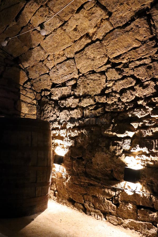 An Inviting, Rustic Stone Wall Paired with an Aged Barrel in a Dimly ...