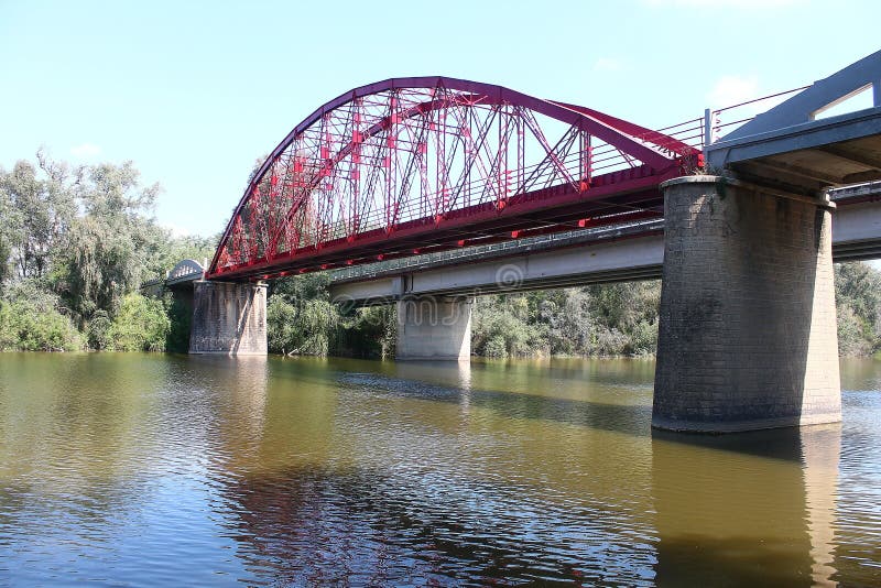 Red iron pedestrian bridge stock photo. Image of tree - 218771780