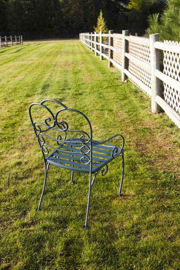 Iron chair by fence. stock image. Image of green, object - 34477901