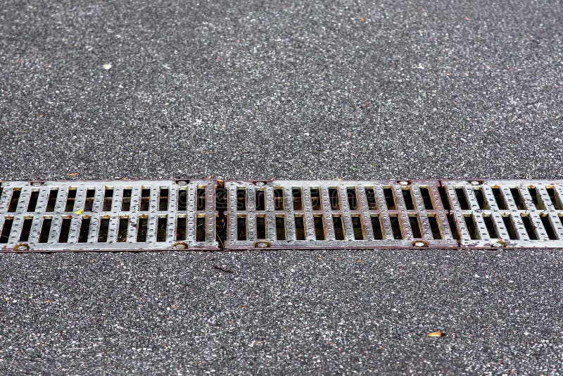 A Iron Grid Drainage System on an Asphalt Road. Stock Photo - Image of ...