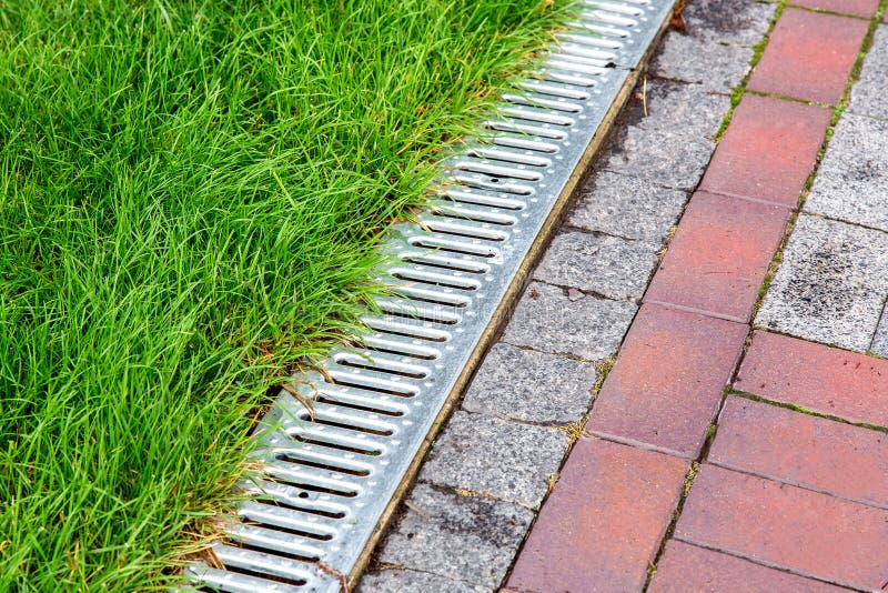 An Iron Gutter with Grate To the Drainage System. Stock Photo - Image ...