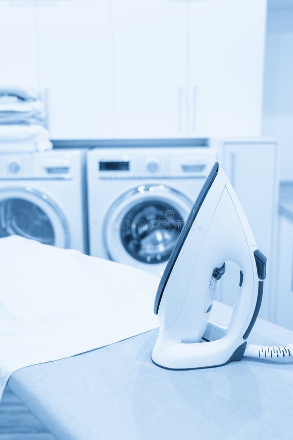 Iron on Ironing Board with White Shirt in Laundry Room Stock Image ...