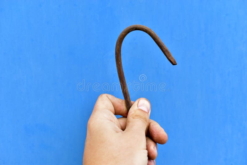 Iron Rusty Hook in Hand on a Blue Background Stock Photo - Image of ...