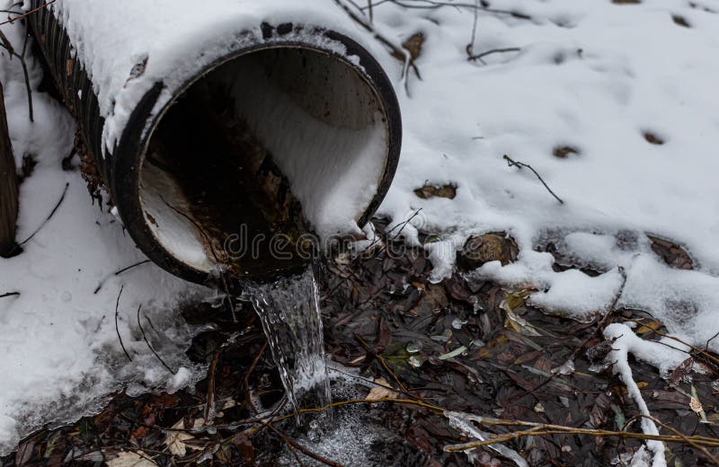 An Iron Snow-covered Pipe from Which a Stream of Water Flows Stock ...