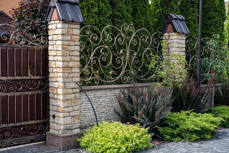Iron Wrought-iron Fence between Decorative Brick Columns in Front of a ...