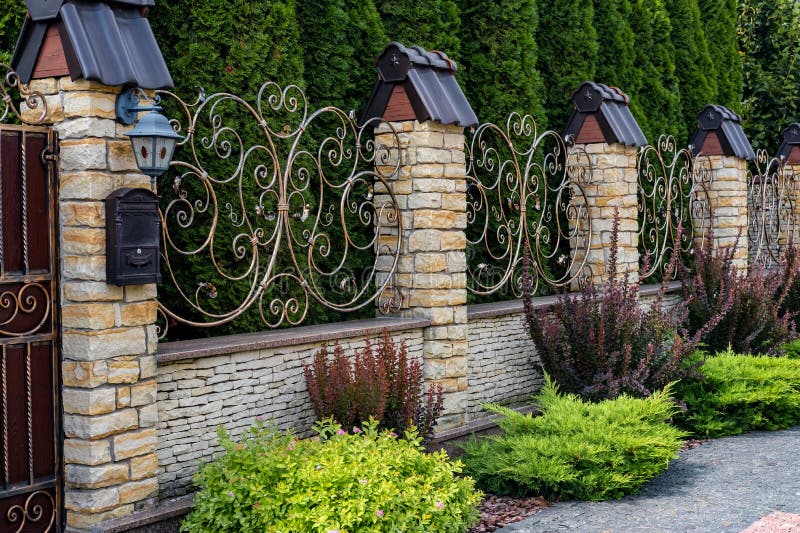 Iron Wrought-iron Fence between Decorative Brick Columns in Front of a ...