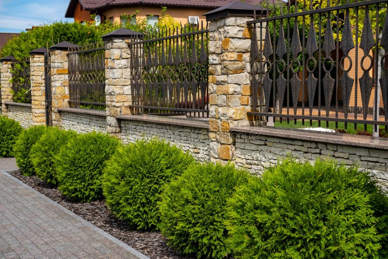 Iron Wrought-iron Fence between Decorative Brick Columns in Front of a ...