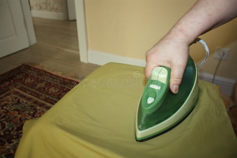 Ironing with iron and hand stock photo. Image of domestic - 146849314
