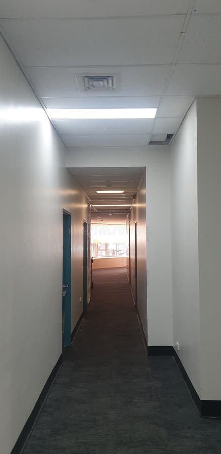 An Irregularly Shaped Corridor with Irregular Lighting White Walls ...